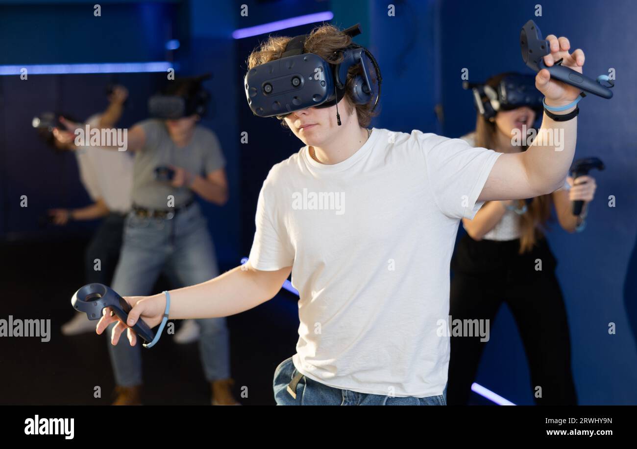 teenager in virtual reality glasses with joystick play survival game in ...