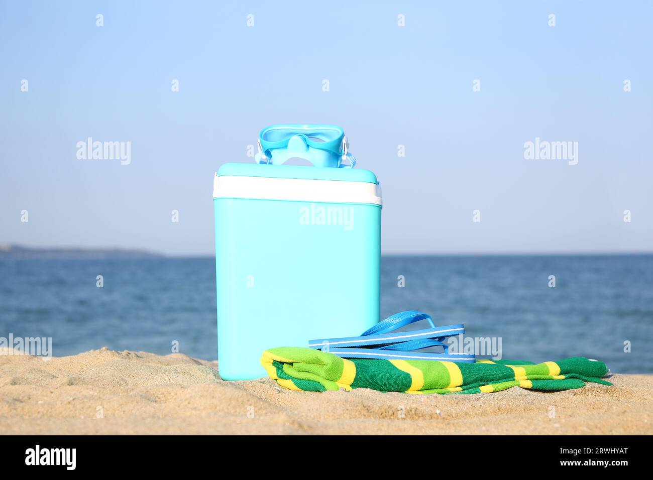 Beach cooler and accessories on sand Stock Photo - Alamy
