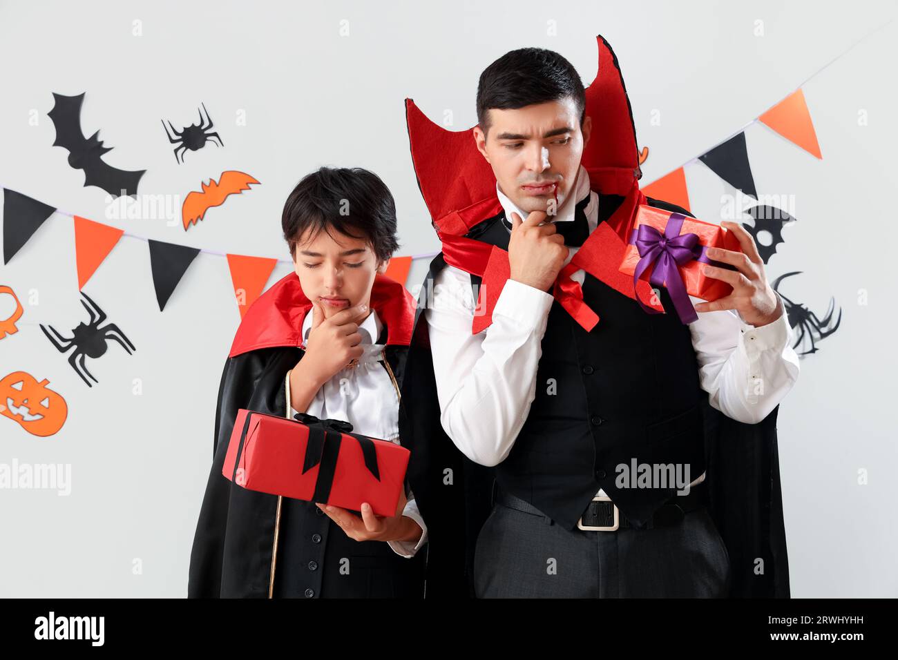 Little boy and his father dressed for Halloween as vampires with gifts ...