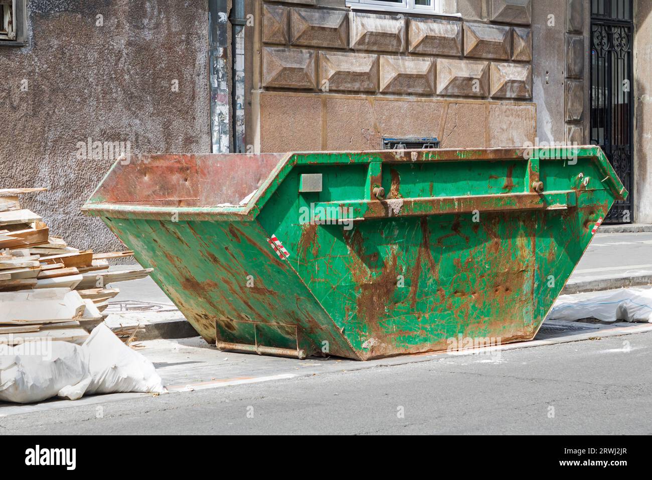 Empty metal skip on the street next to construction site Stock Photo ...