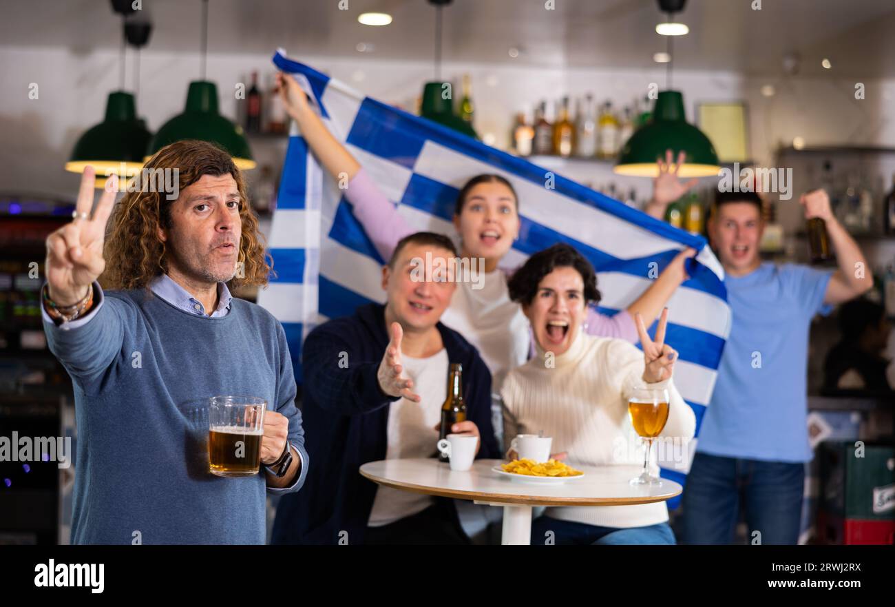 Group of emotive friends supporters cheering for favorite team with ...