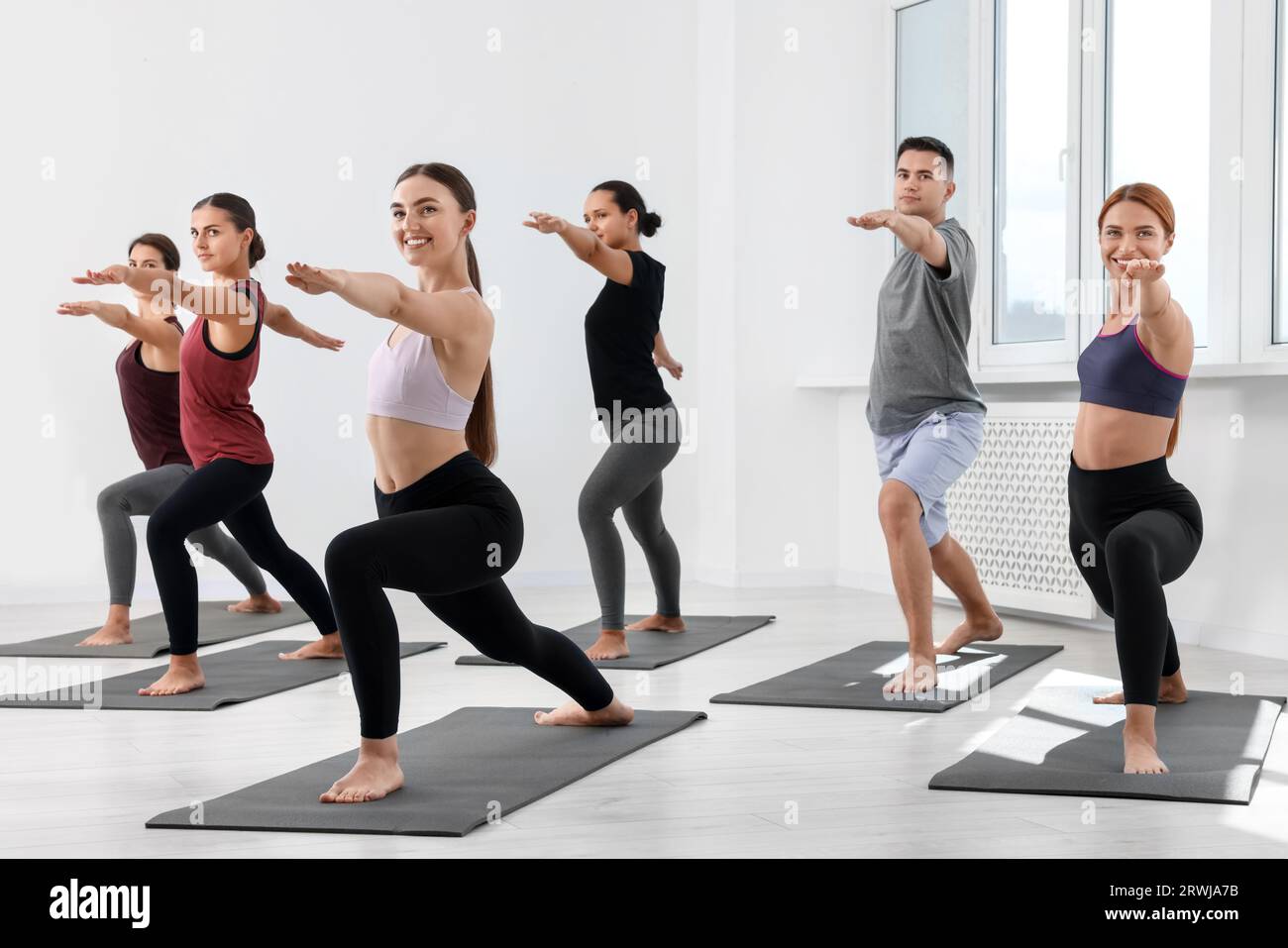 Group people practice warrior yoga hi-res stock photography and images ...