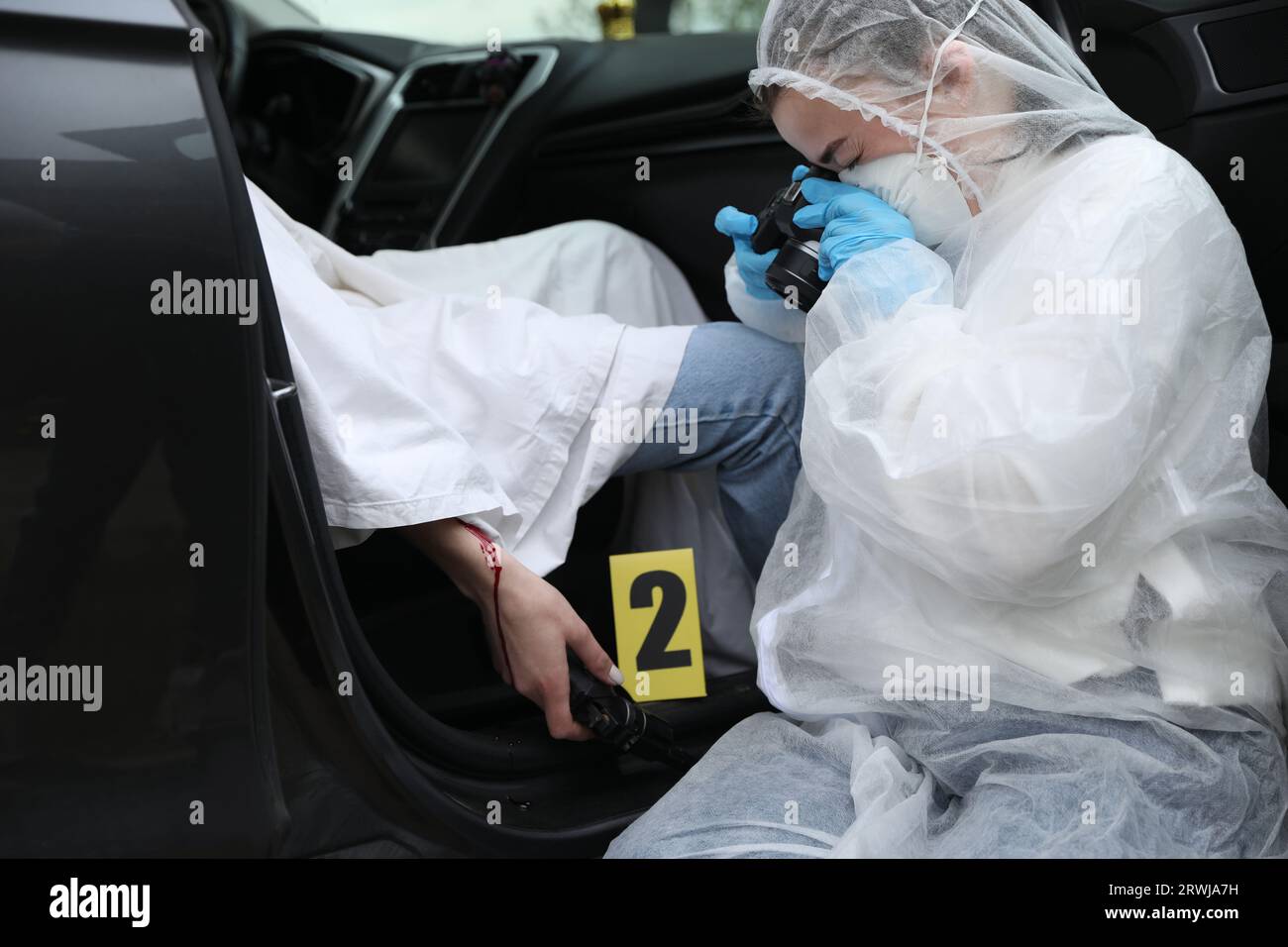 Criminologist taking photo of evidence at crime scene with dead body in ...