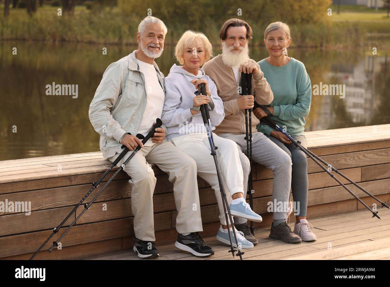 Group of senior people with Nordic walking poles sitting on wooden ...