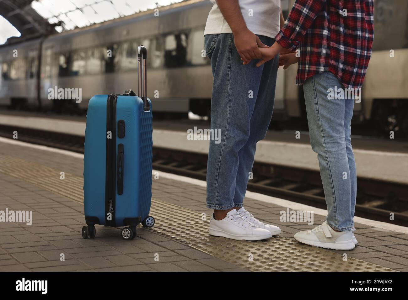 Long-distance relationship. Couple holding hands on platform of railway ...