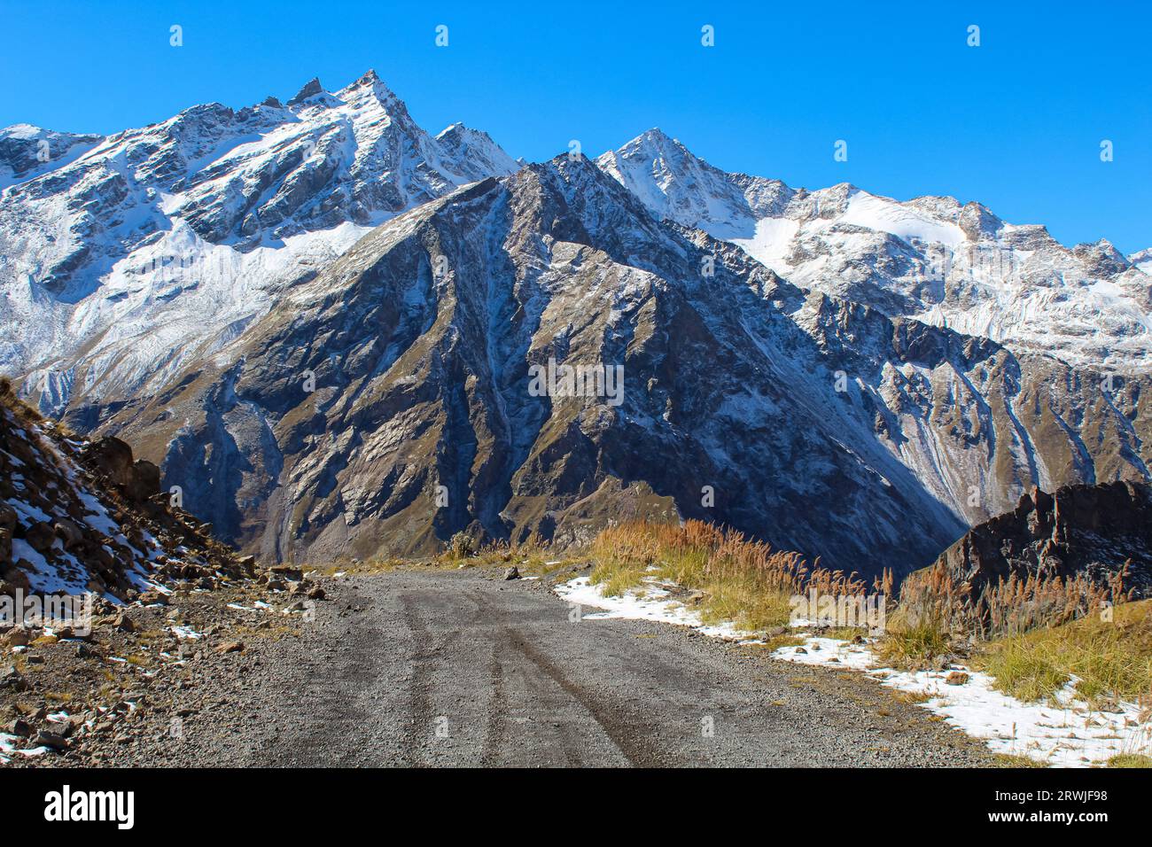 A path going through the tall mountains in Elbrus region, Russia ...