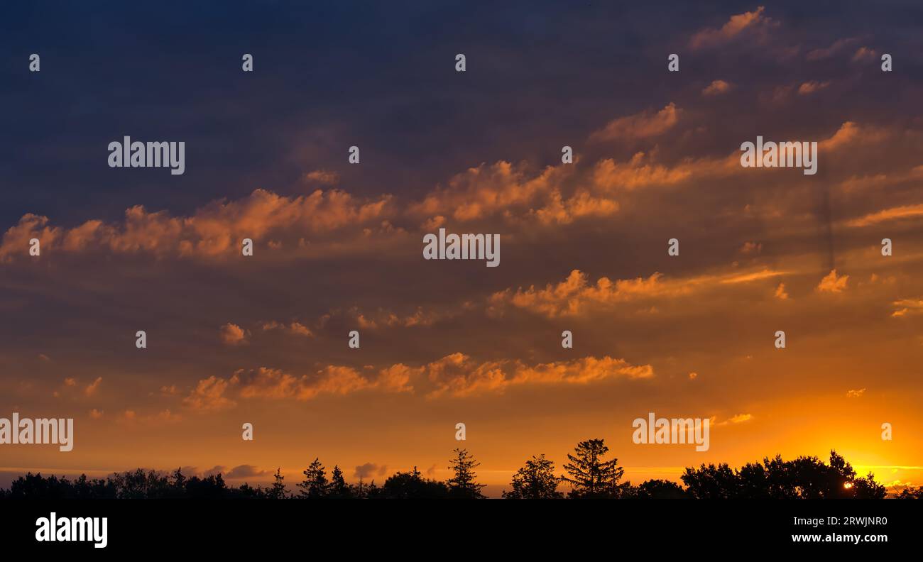 Stunning sunset with sky filled with clouds is beautifully painted with ...