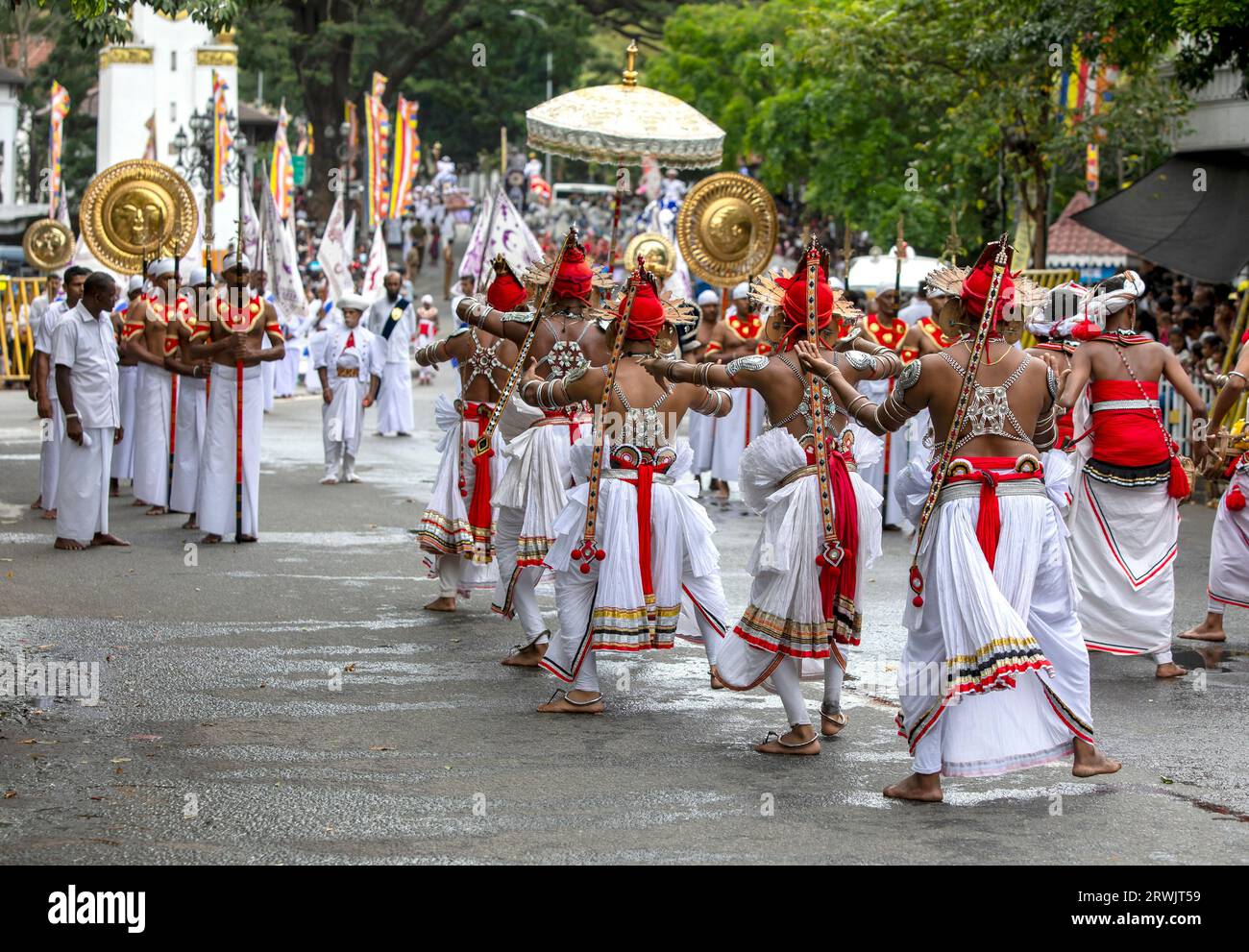 Kandyan or Up Country Dancers wearing a tailed hat perform along a road ...