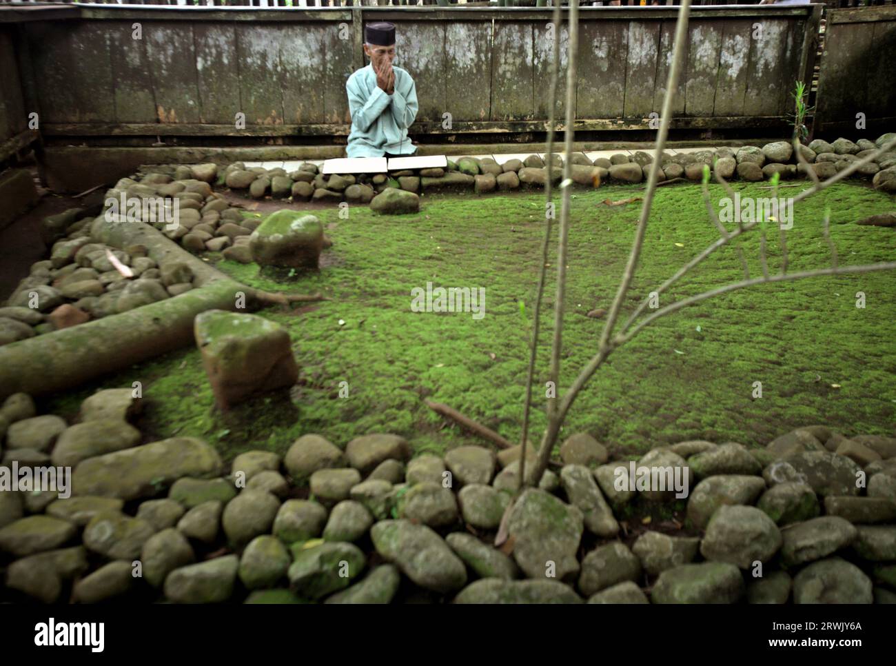 A caretaker prays at a megalithic structure that is considered a sacred ...