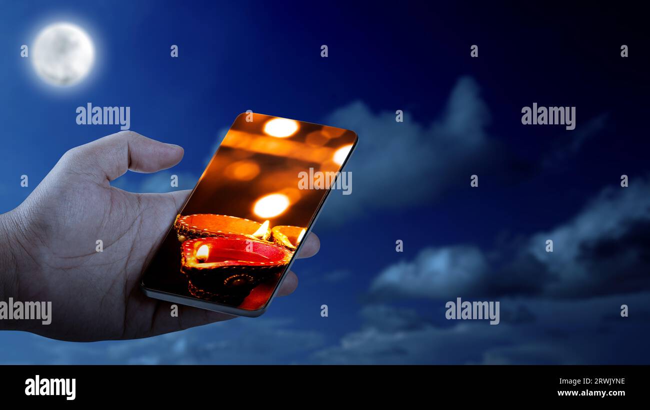Human hand showing Diya oil lamps for the Diwali festival on the mobile ...