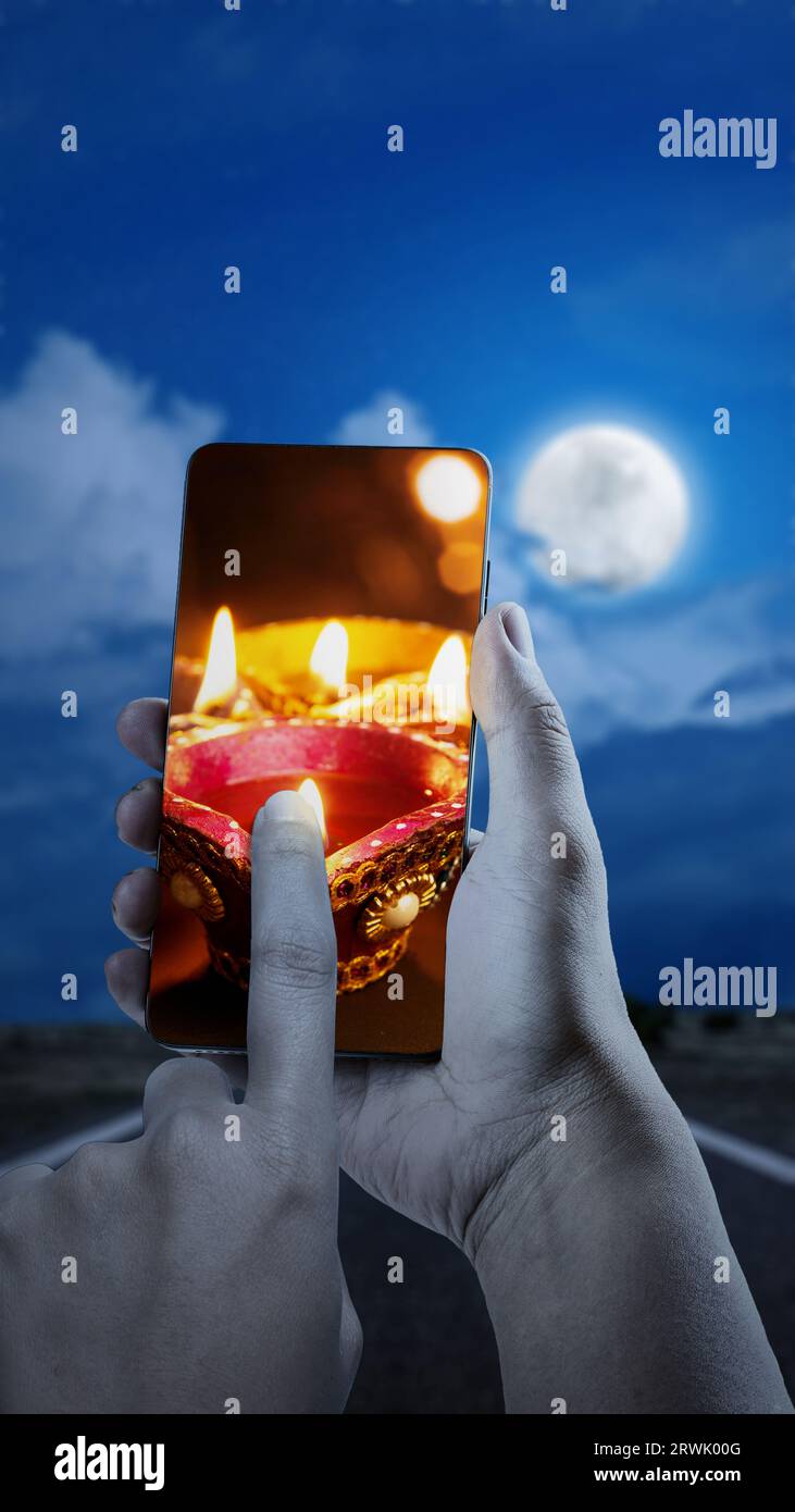 Human hand showing Diya oil lamps for the Diwali festival on the mobile ...