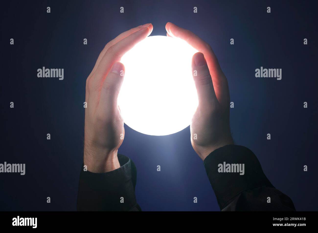 Hands holding a glowing sphere shaped object Stock Photo - Alamy