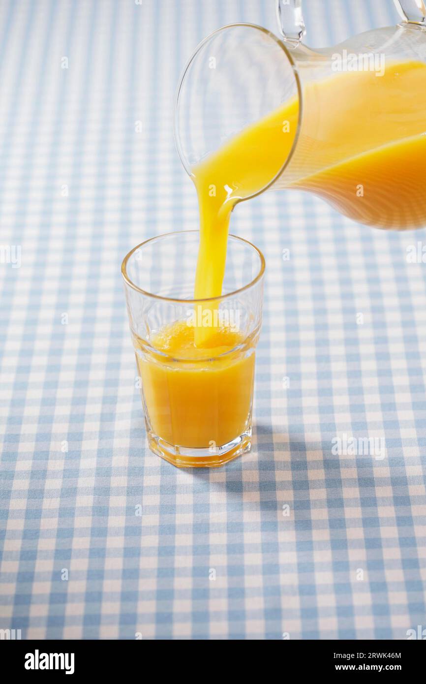 Orange juice being poured from a jug to a glass Stock Photo - Alamy