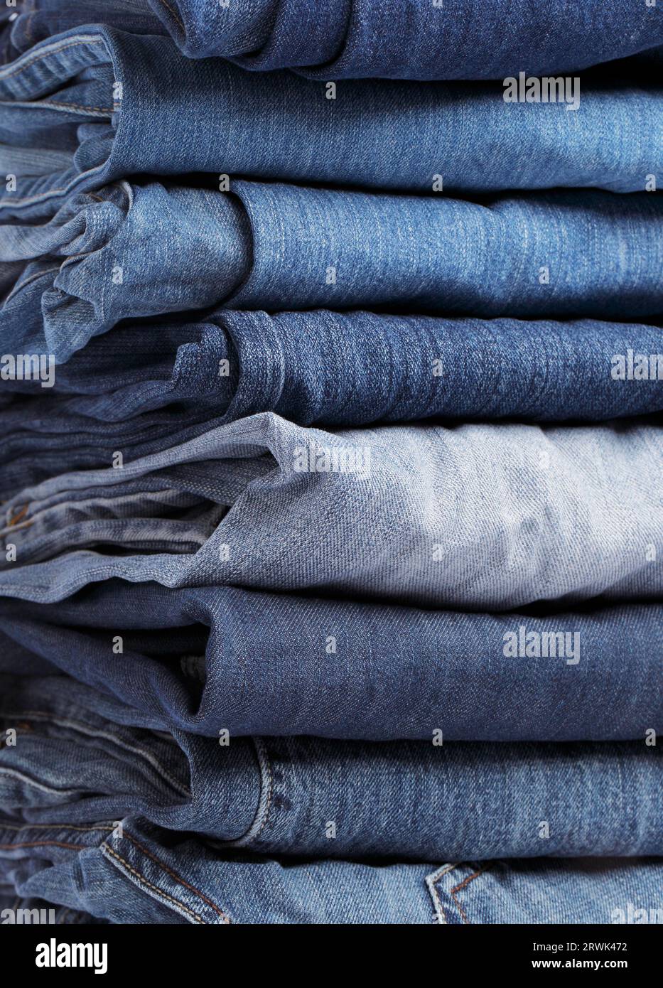 Different shades of blue jeans stacked Stock Photo - Alamy