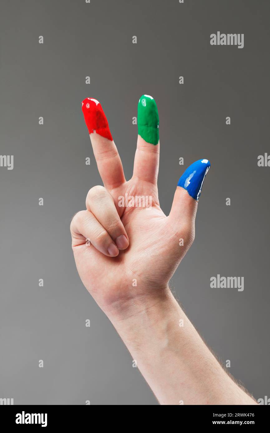 Fingers with fingerpaints in three primary colors, Red, green and blue ...