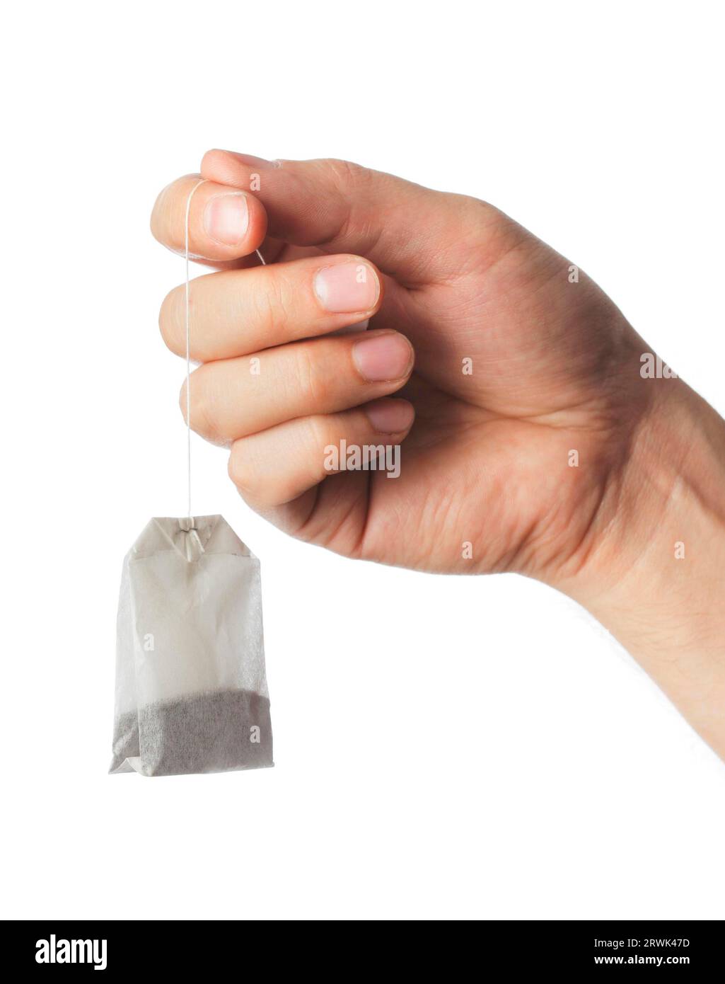 Hand holding a dry tea bag Stock Photo - Alamy