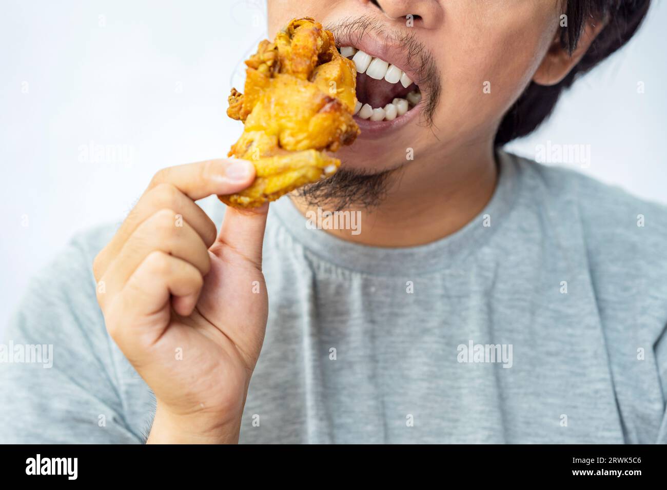 Man eating pecel ayam with a white background. Traditional Indonesia ...