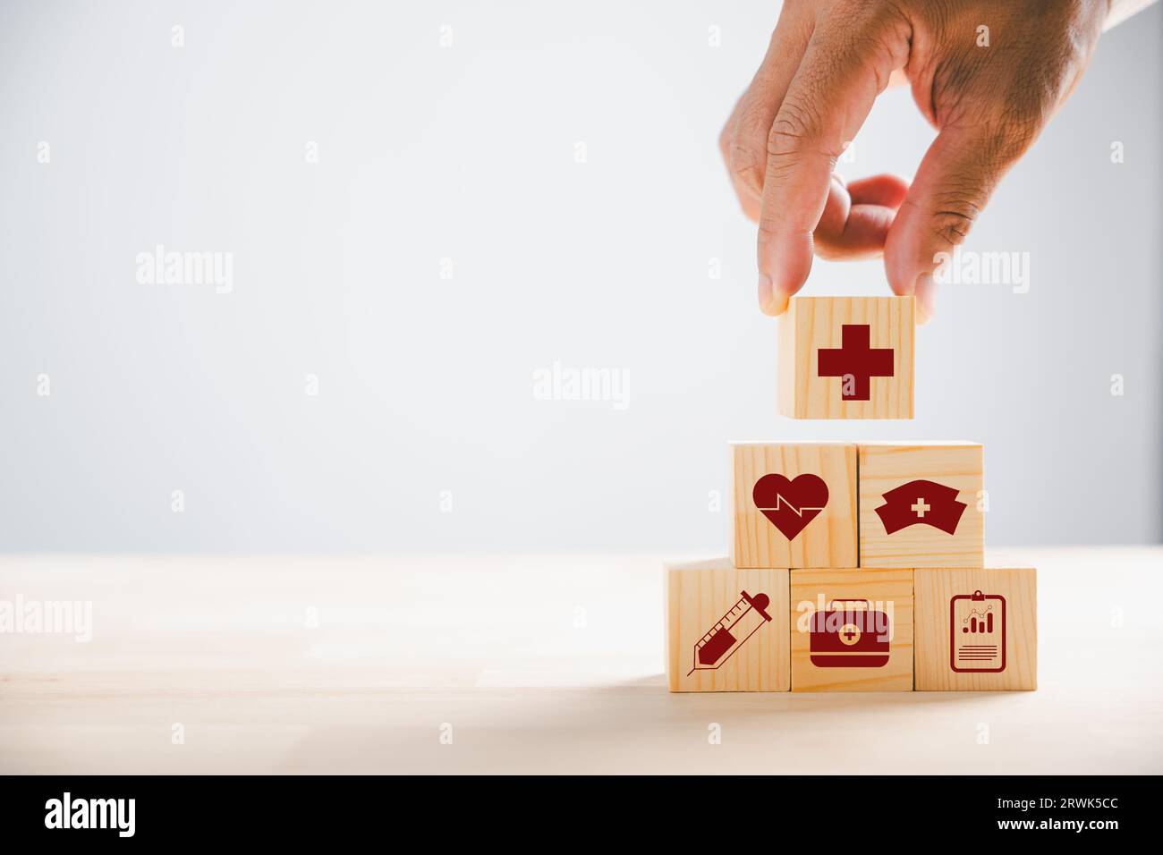 Hand hold wooden block with icon healthcare medical Stock Photo - Alamy
