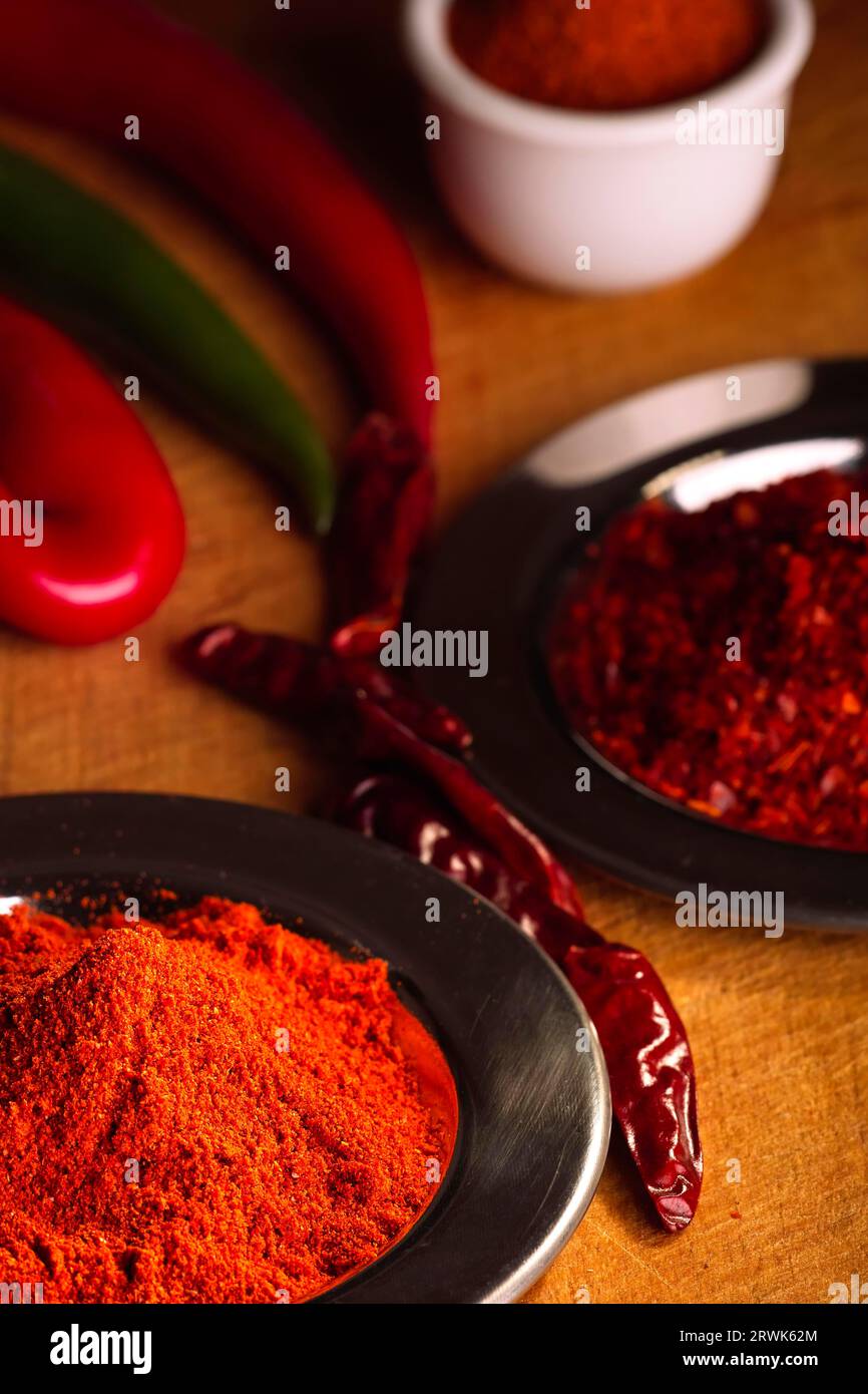 Ground paprika and chilli peppers on plates Stock Photo - Alamy