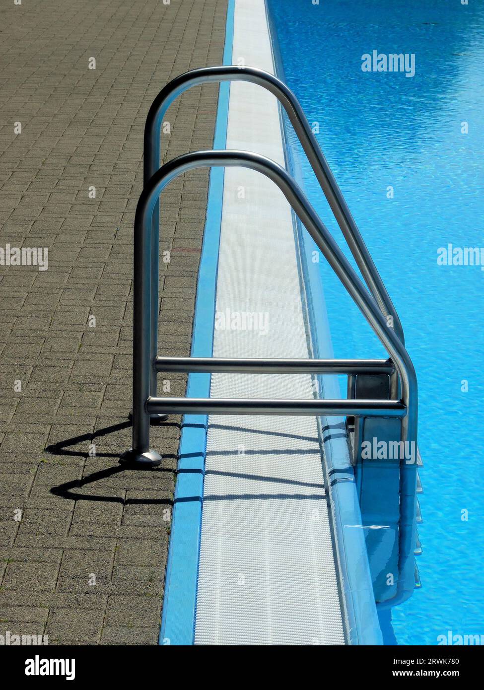 Metal ladder leading into the pool of an outdoor swimming pool, PR ...