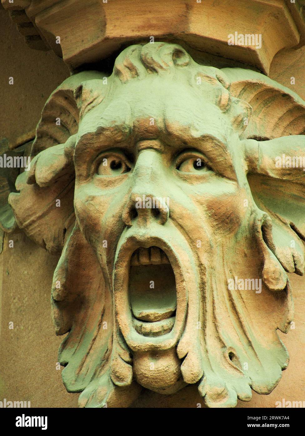 Slightly weathered sandstone portrait with open mouth, format-filling ...