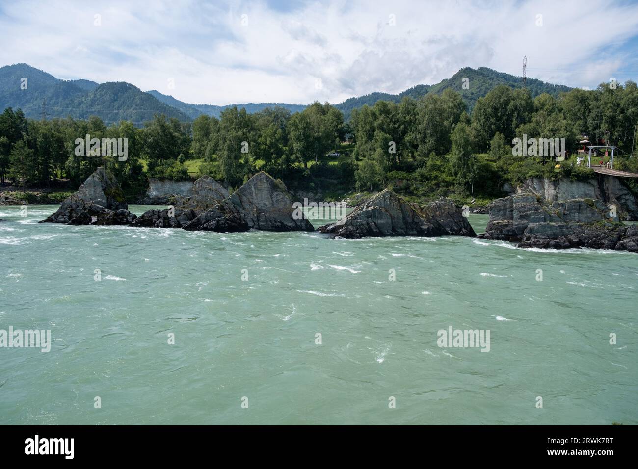 A wide, full-flowing mountain river with a fast current Stock Photo - Alamy