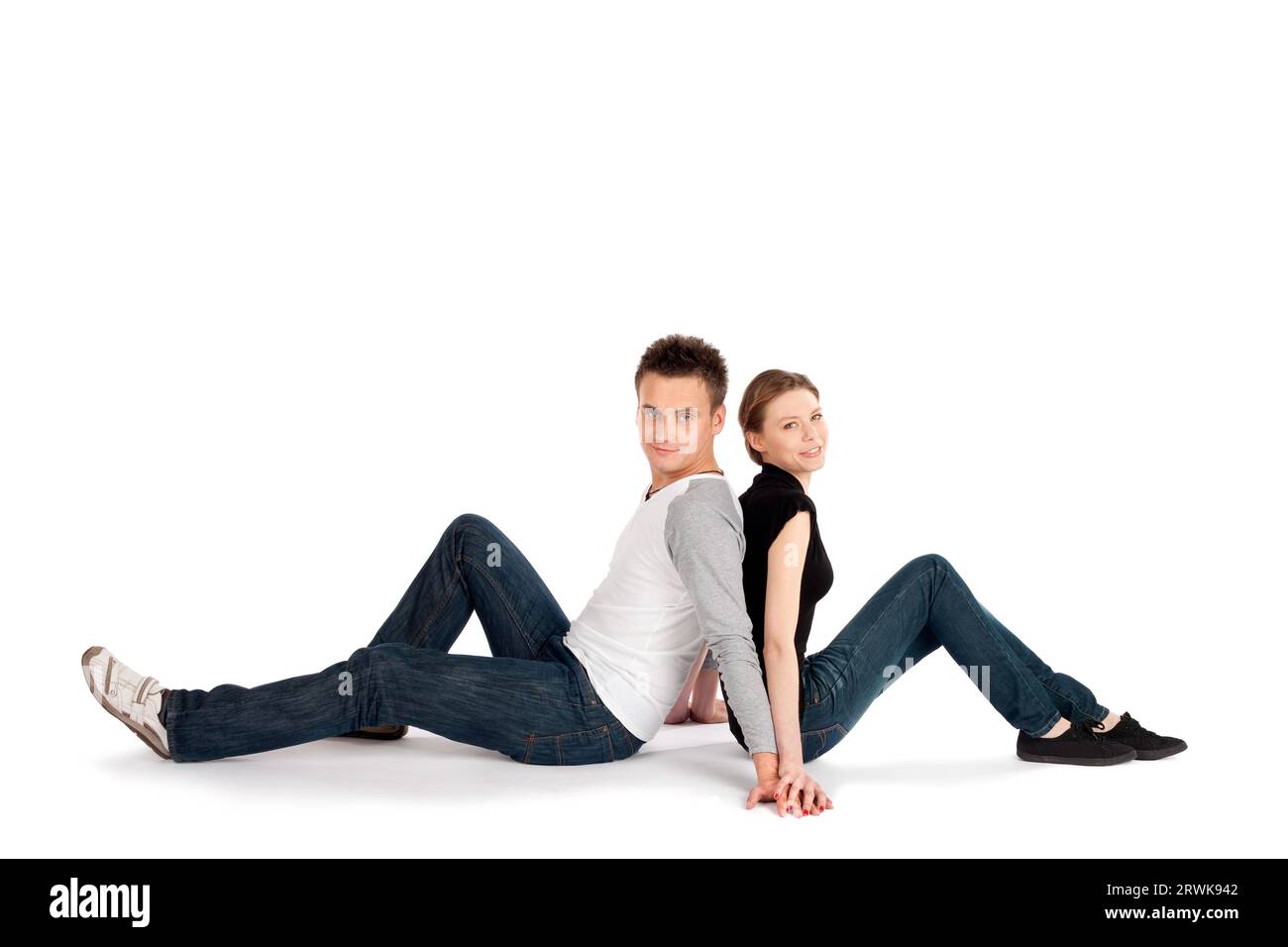Young attractive happy couple sitting back to back isolated on white ...