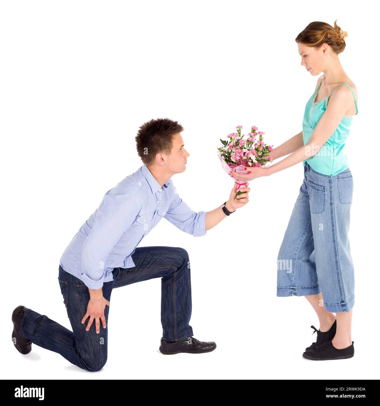 Young man handing over a flowers to his girlfriend, isolated on white ...