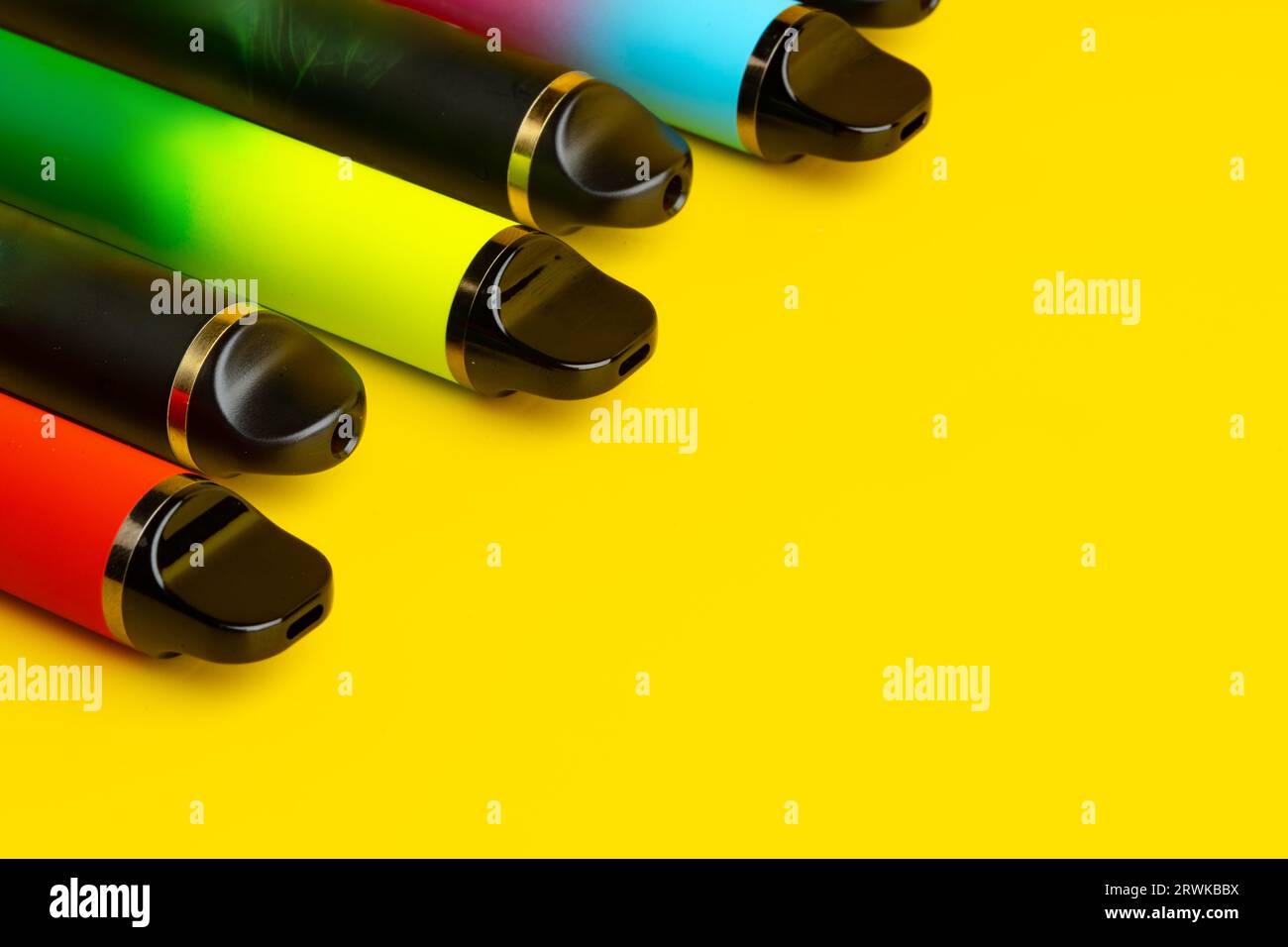 Colorful disposable electronic cigarettes on yellow background Stock ...