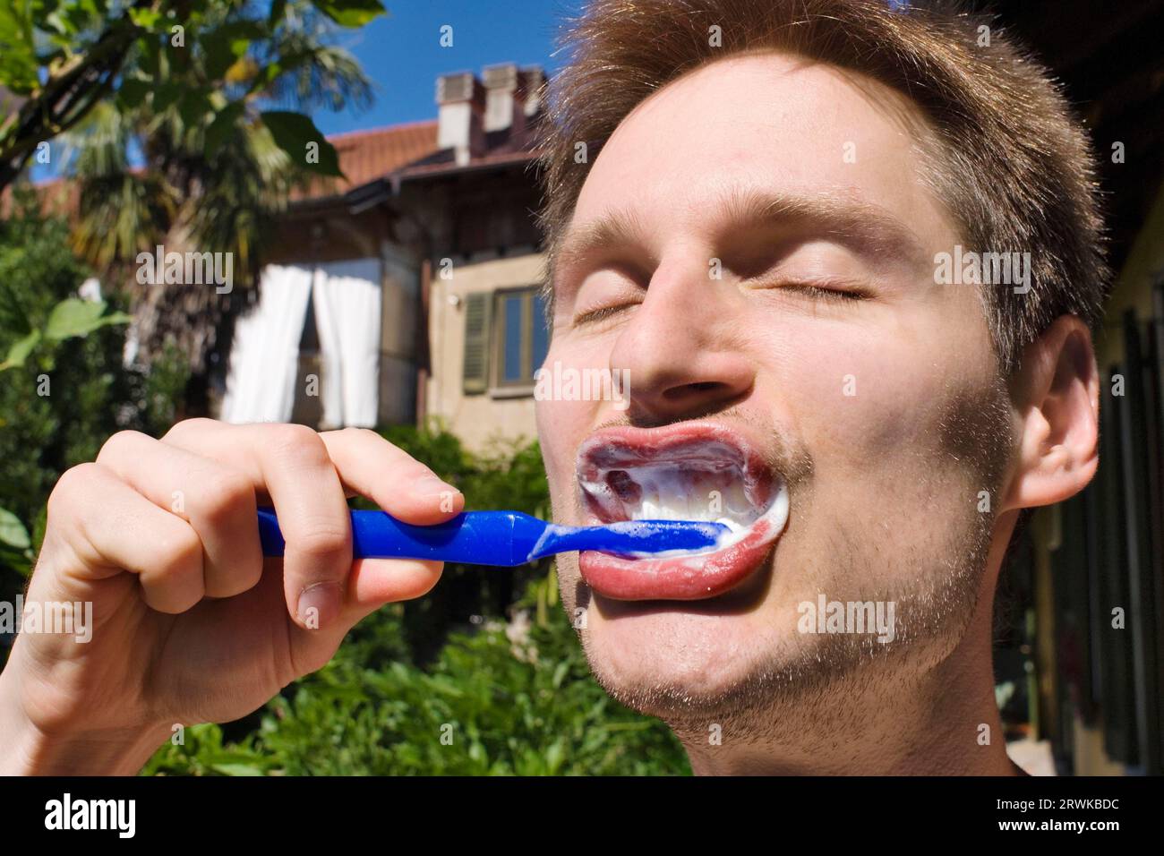 A man taking care of his teeth outdoors Stock Photo - Alamy