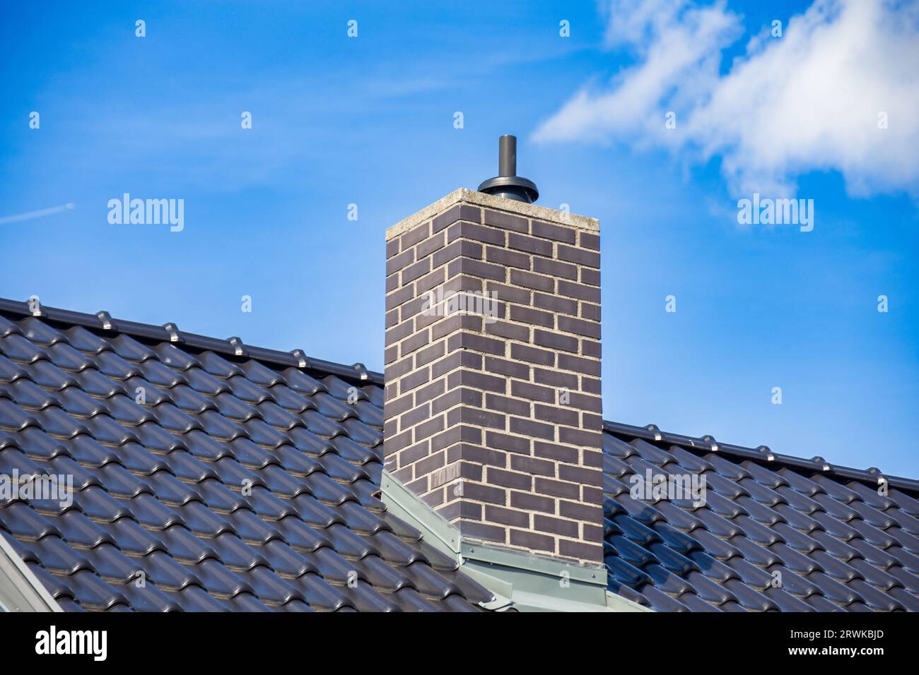 Chimney clad with clinker bricks on a tiled roof Stock Photo - Alamy