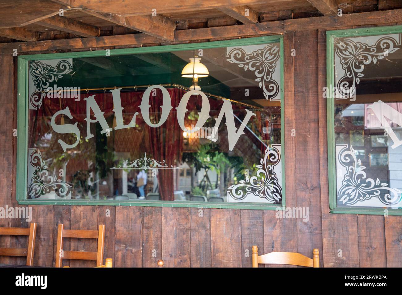 Western town saloon sign text on old windows and wooden farwest facade ...