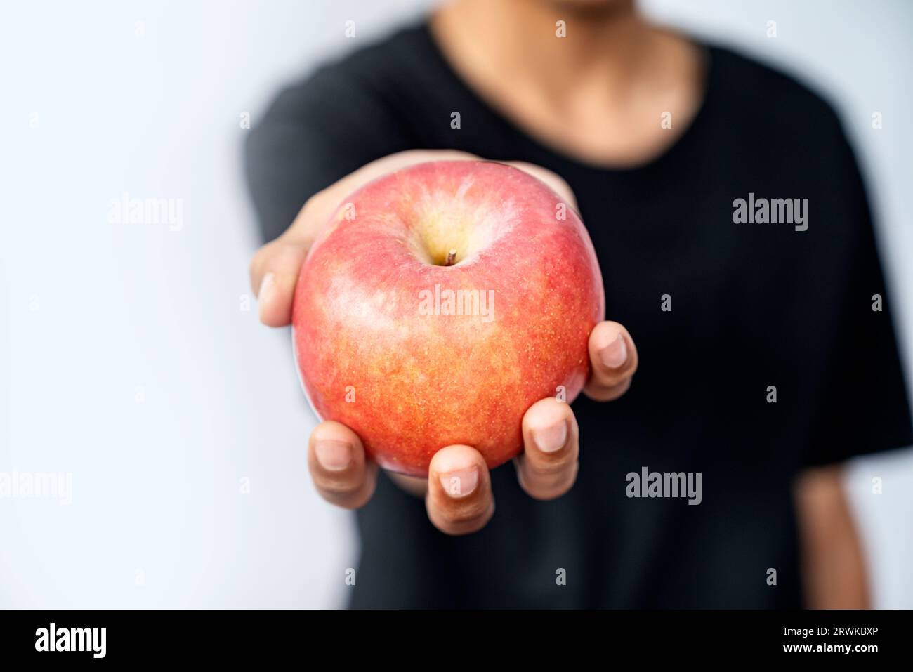 A human hand holding an apple fruit with a white background Stock Photo ...