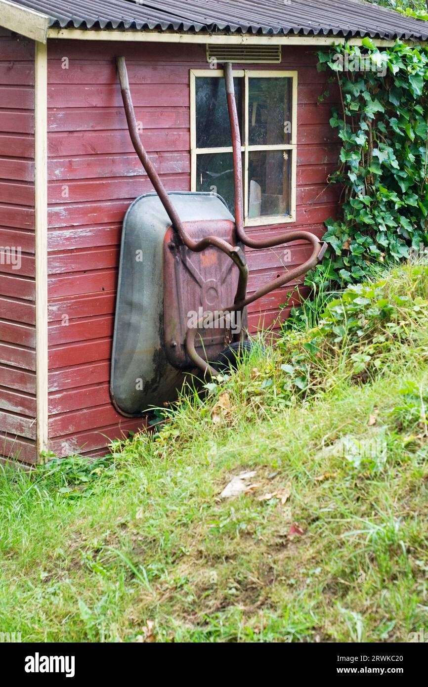 A wheelbarrow stands by a garden shed Stock Photo - Alamy