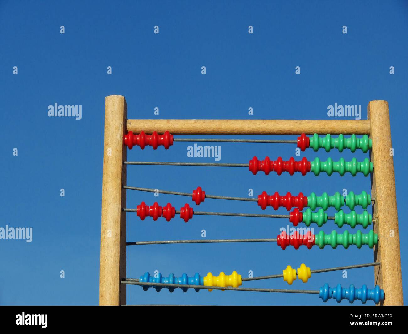 Wooden slide rule with red, yellow, blue and green counting discs ...