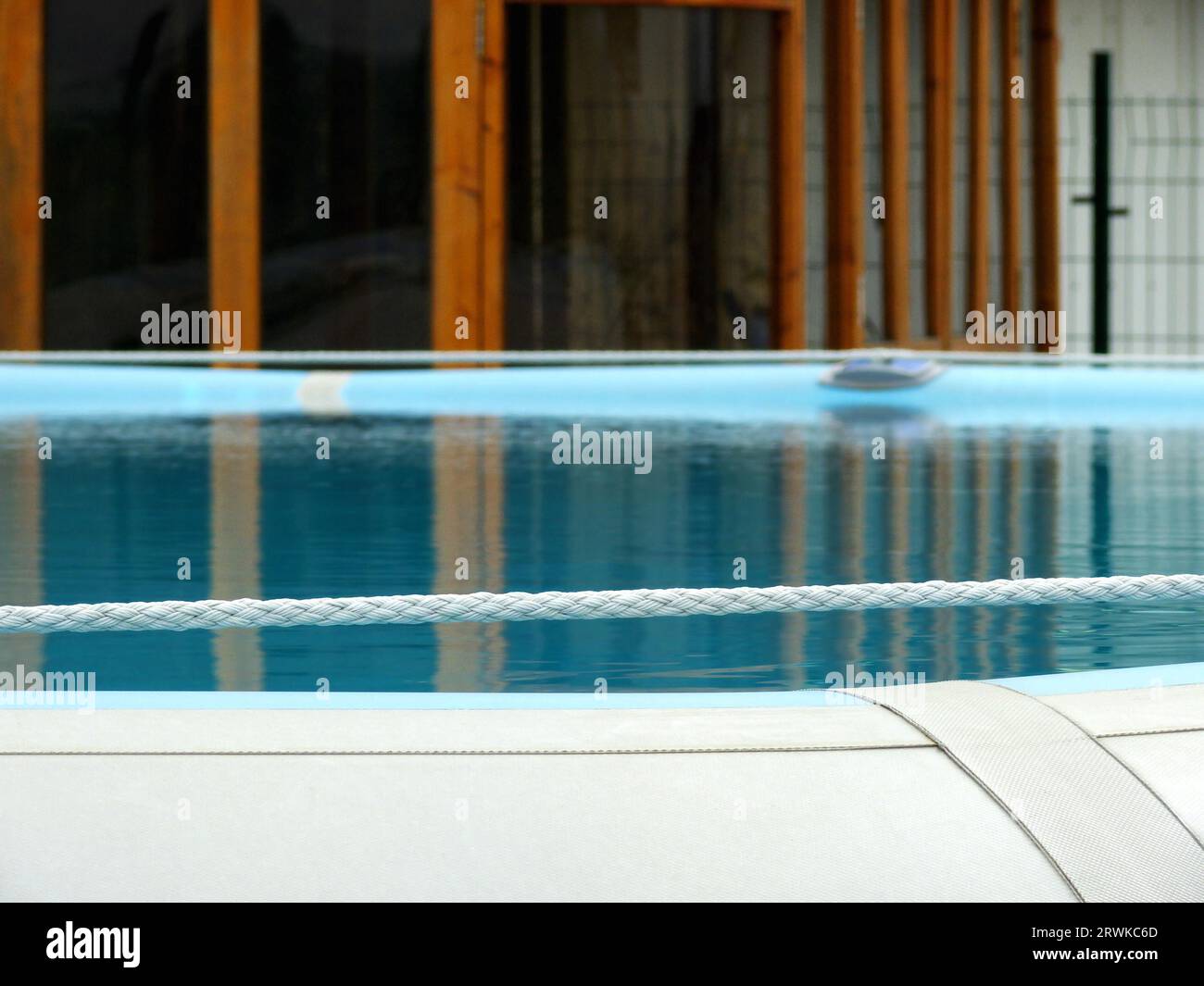 Filled swimming pool with white border, background building in blur ...