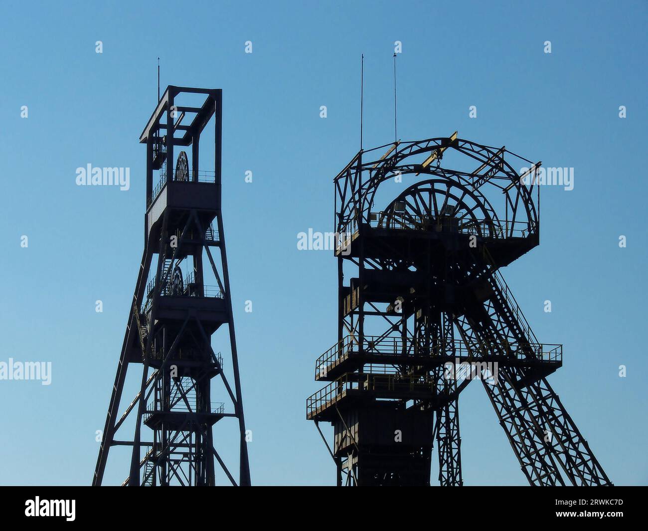 Two winding towers on a mine site, background blue sky Stock Photo - Alamy