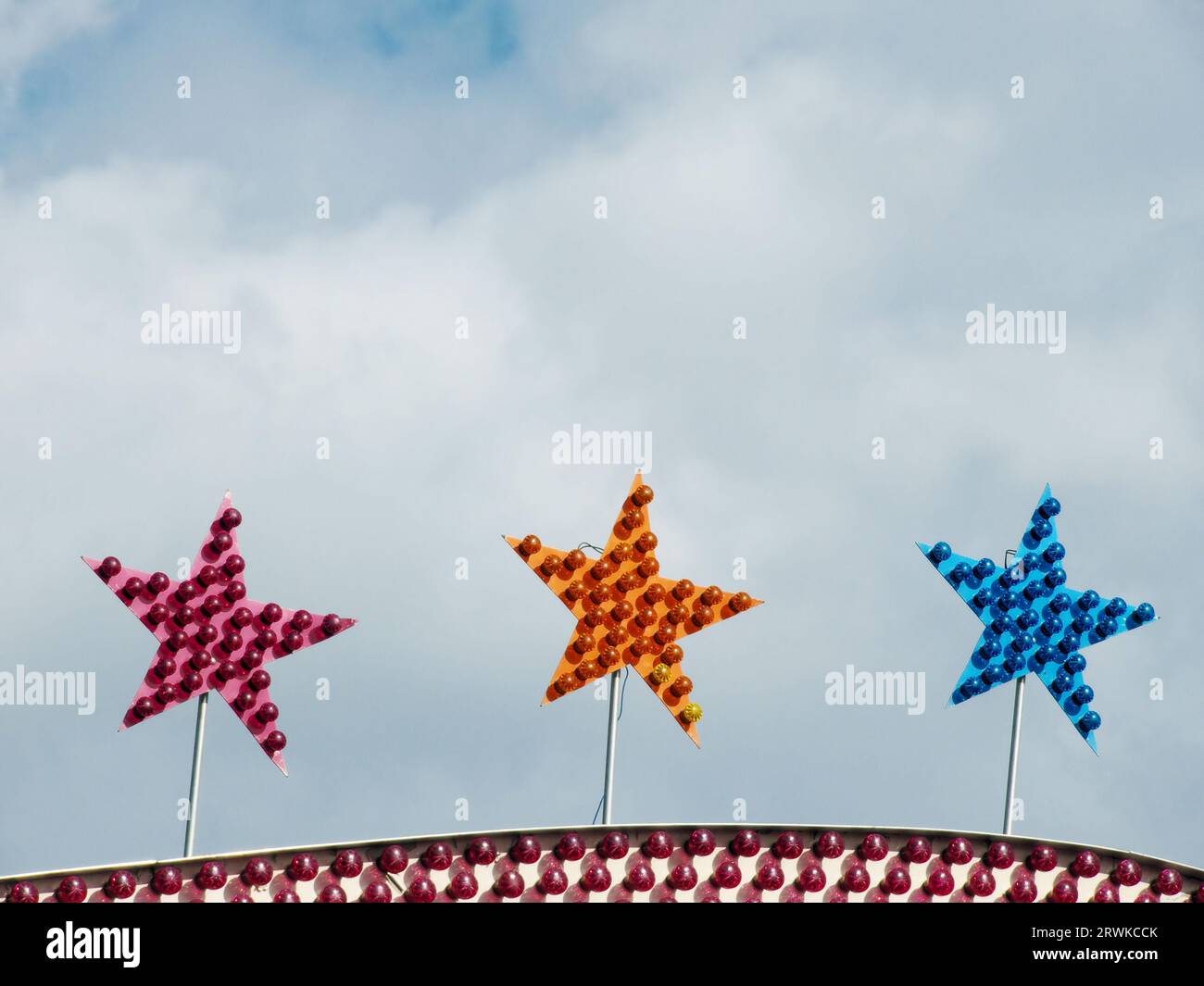 Three stars in the colours pink, orange and blue with illuminant on a ...