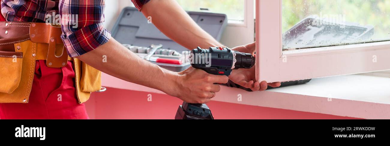 installation of plastic in a frame house, the builder screws the window ...