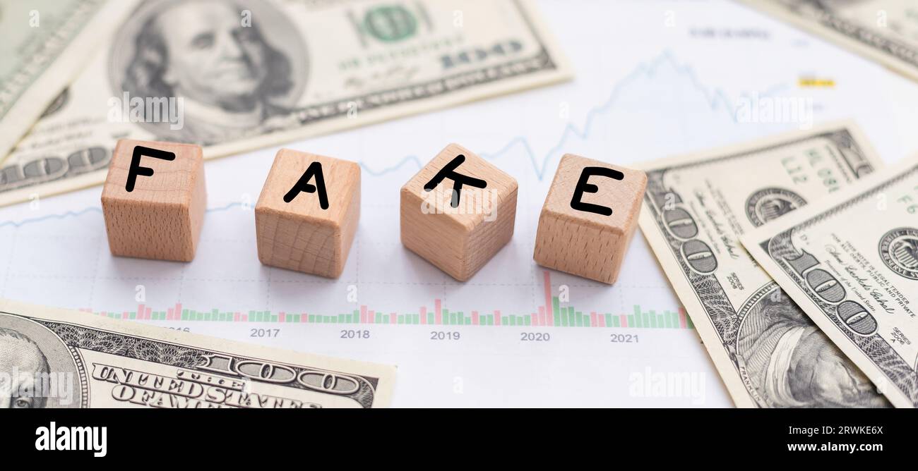 The word FAKE, spelt with wooden letter tiles, over a white background ...