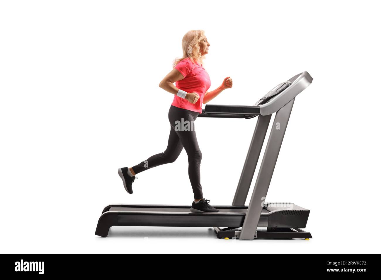 Full length profile shot of a mature woman running on a treadmill ...