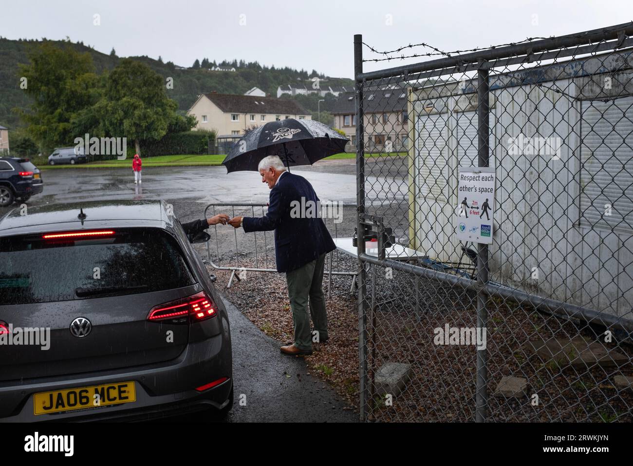 A club official taking money at the entrance gate before Oban Camanachd ...