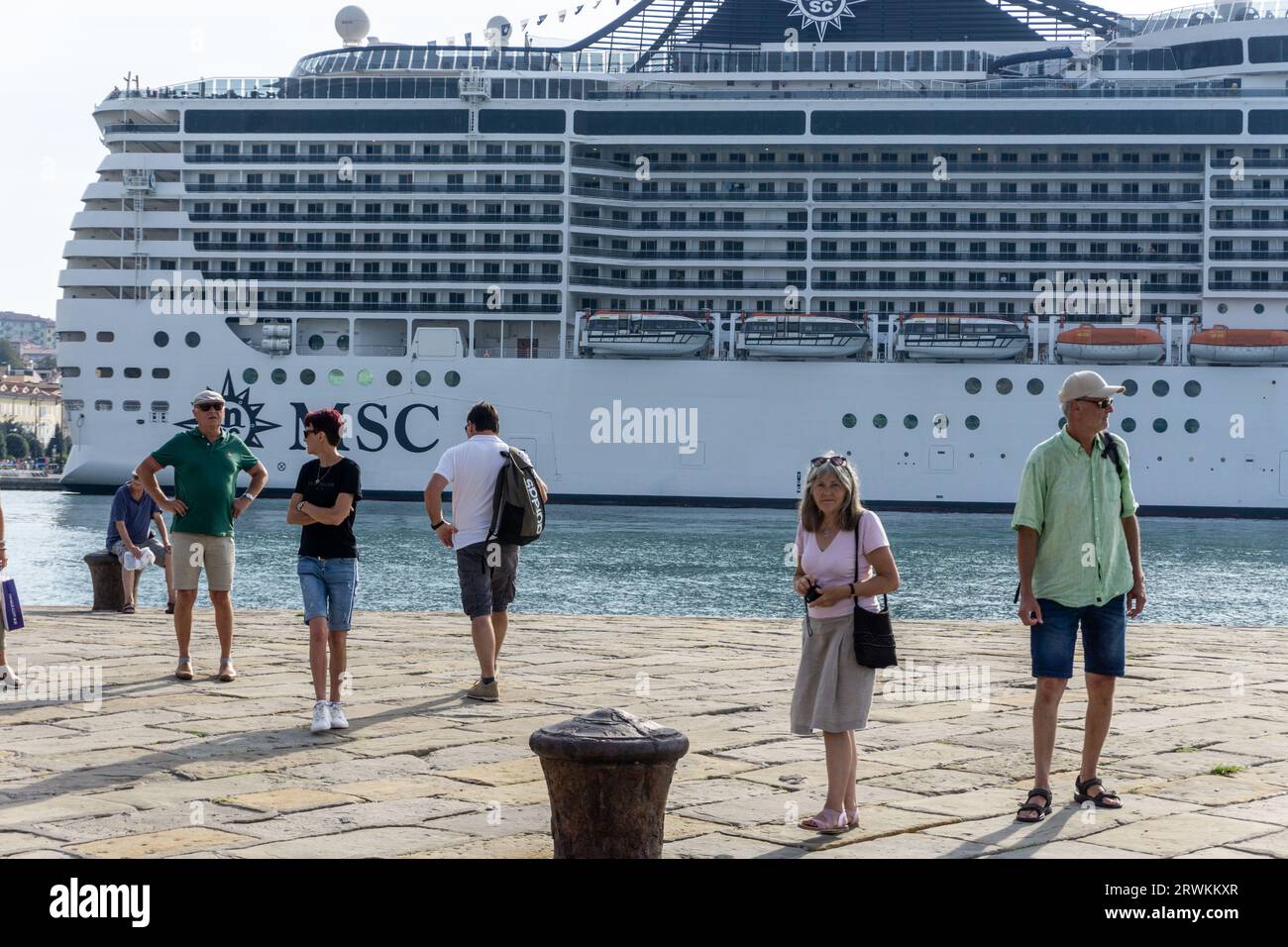 People waiting on dock in Trieste with cruise ship in background Stock ...