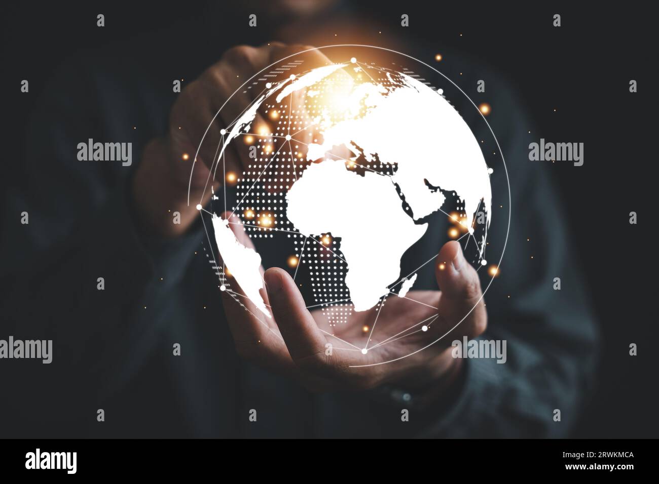A businessman's hand holds a globe, illustrating seamless connectivity ...