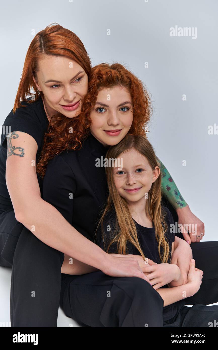 three generations concept, positive redhead family in matching outfits ...