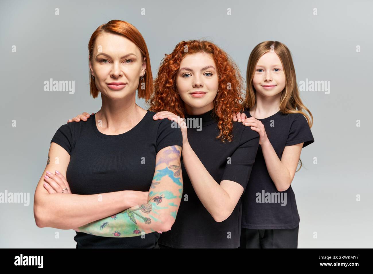 three generations of happy women and girl posing in matching outfits on ...