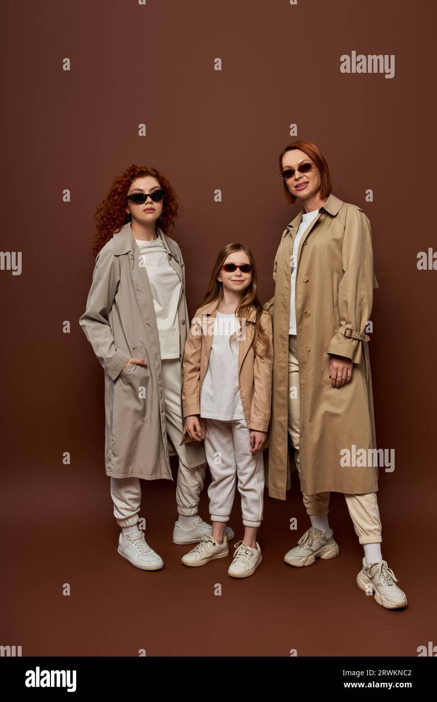 family photo of female generations in sunglasses and coats posing on ...