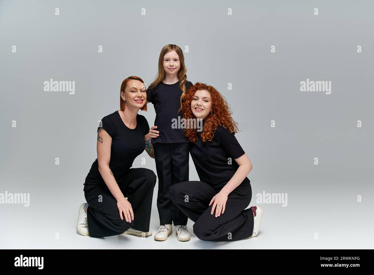 family portrait, three generations of women in matching clothes looking ...