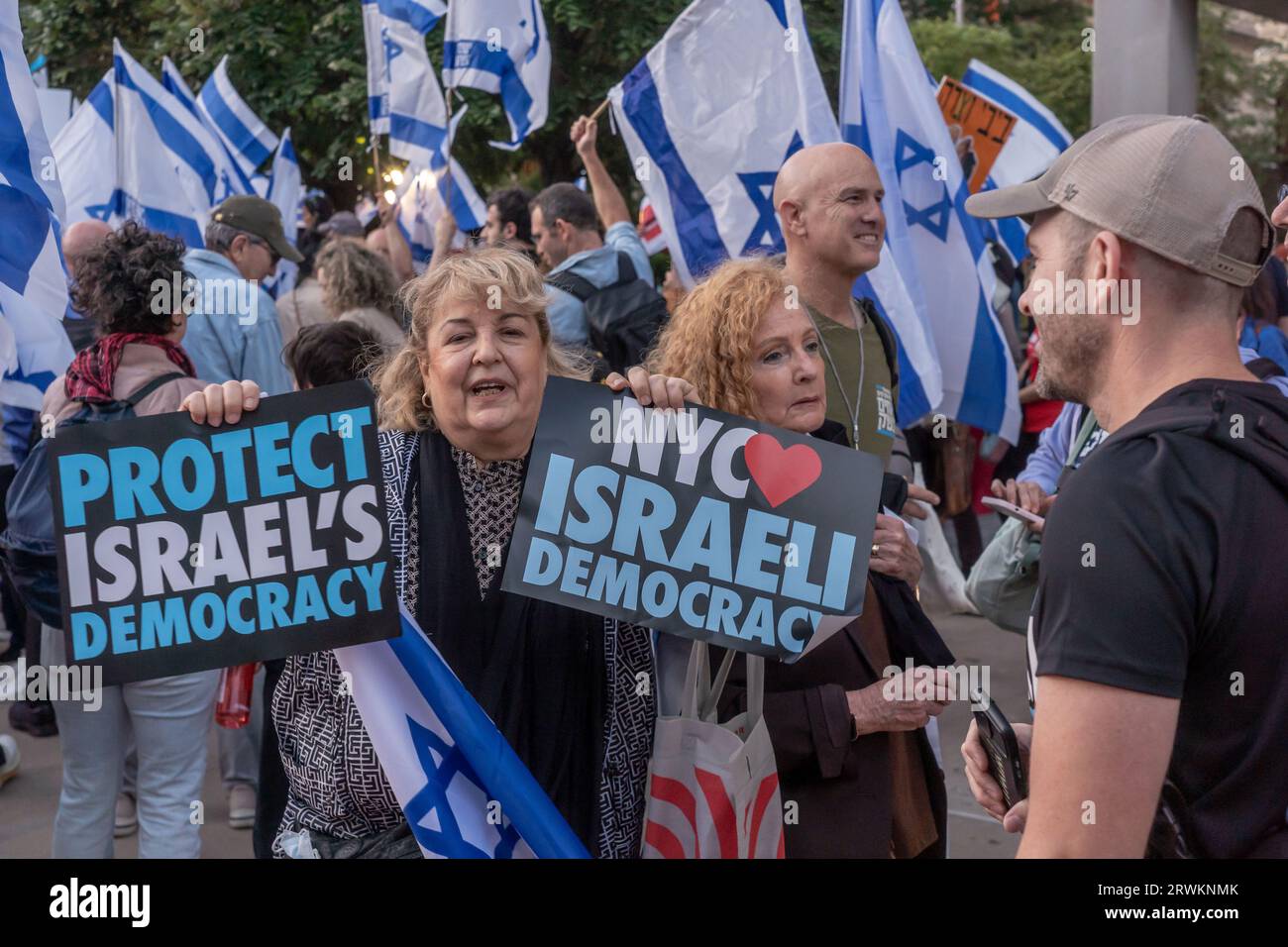 Protester holds a "protect Israel's Democracy" and "NYC [love] Israeli ...