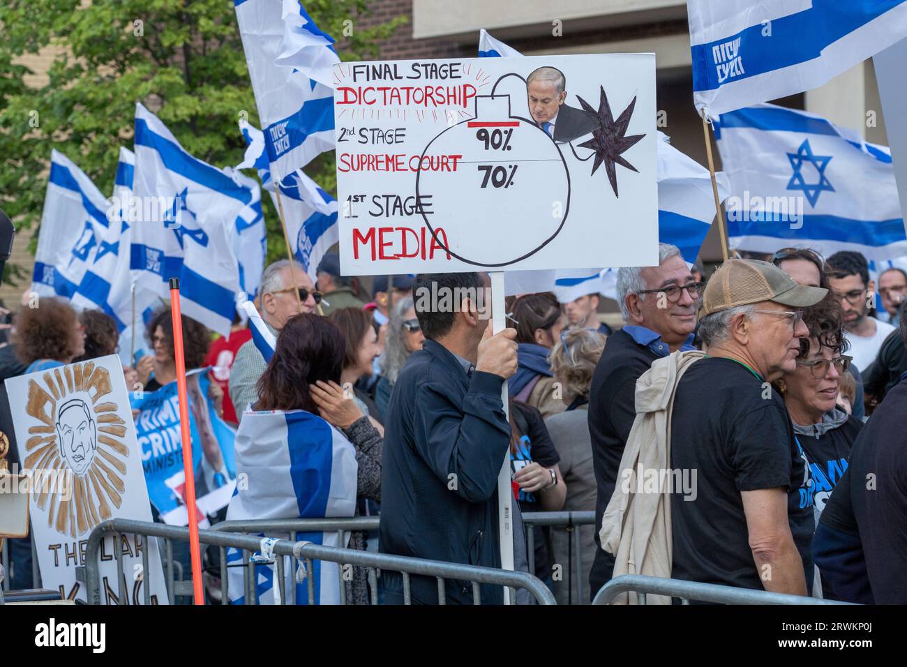 An Israeli Expat holds a placard indicating Netanyahu is trying to ...